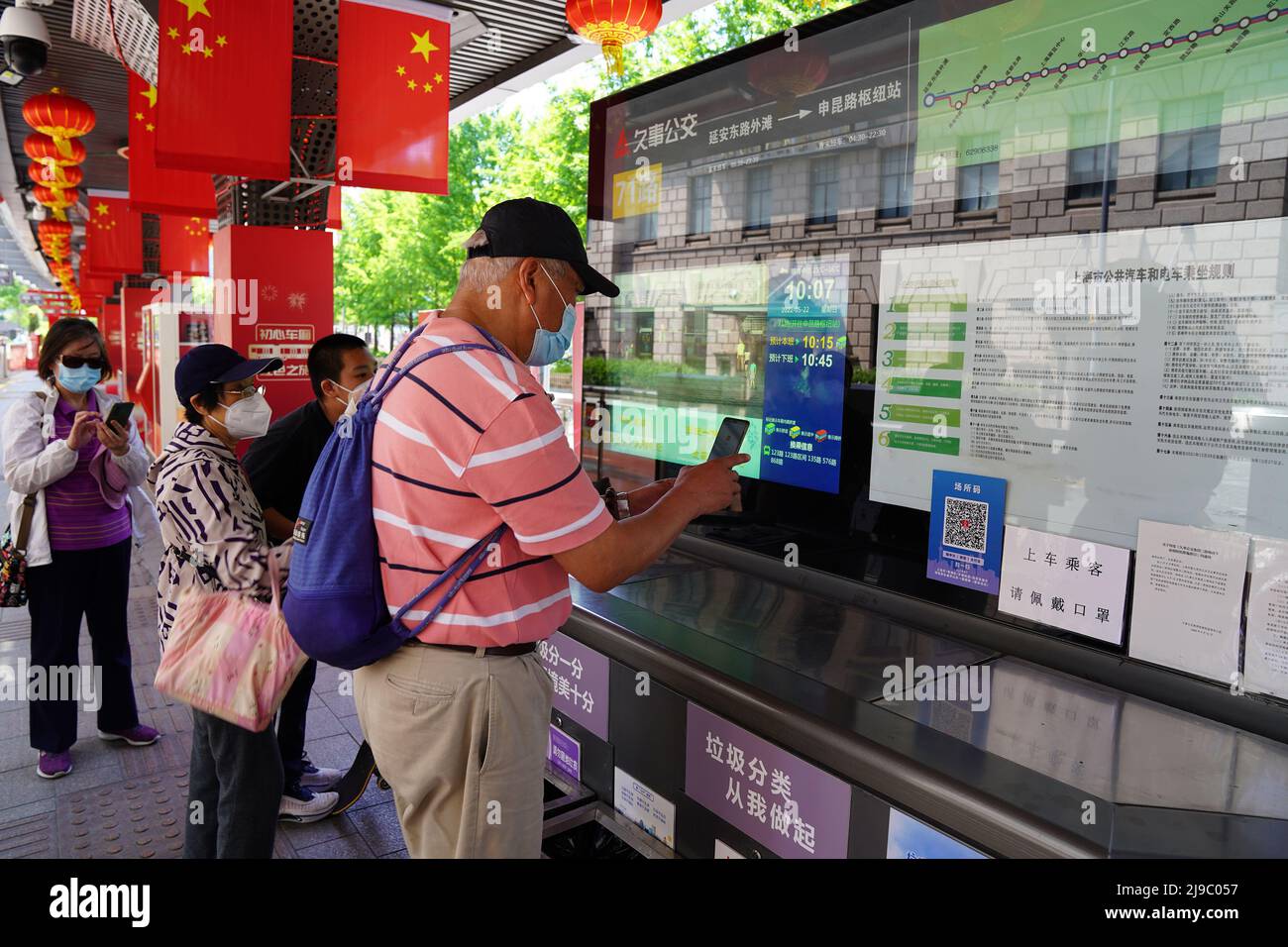 Shanghai, China. 22nd May, 2022. A man scans the QR code at a bus stop ...
