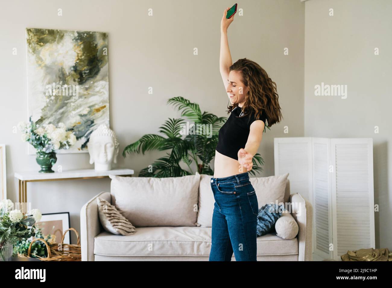 Beautiful young woman dancing at home alone in headphones Stock Photo ...