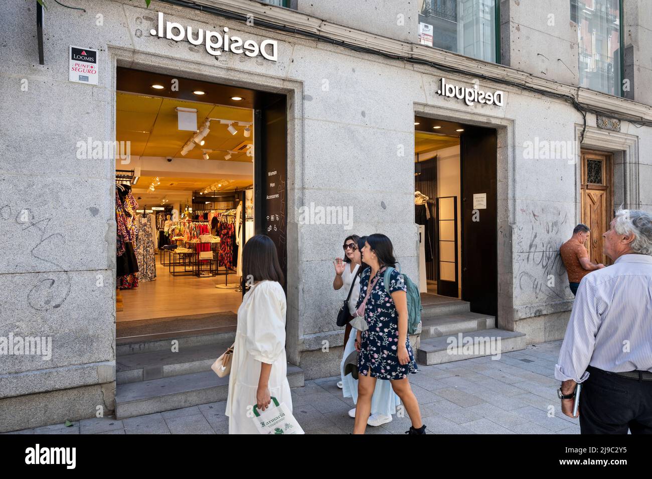 Pedestrians walk past the Spanish clothing brand Desigual store in ...