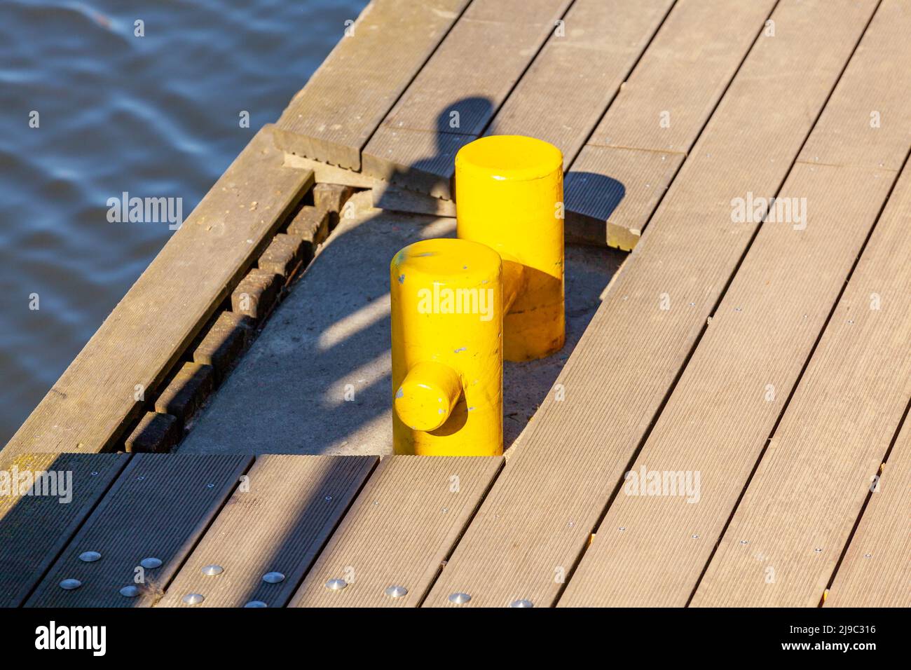 Yellow mooring post on deck by the sea background Stock Photo - Alamy