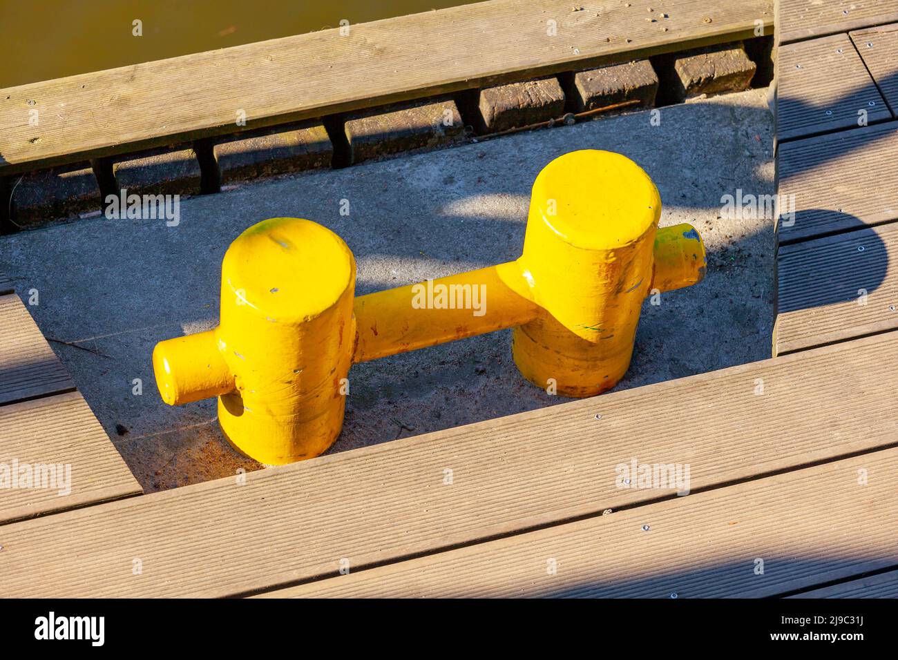 Yellow mooring post on deck by the sea background Stock Photo - Alamy