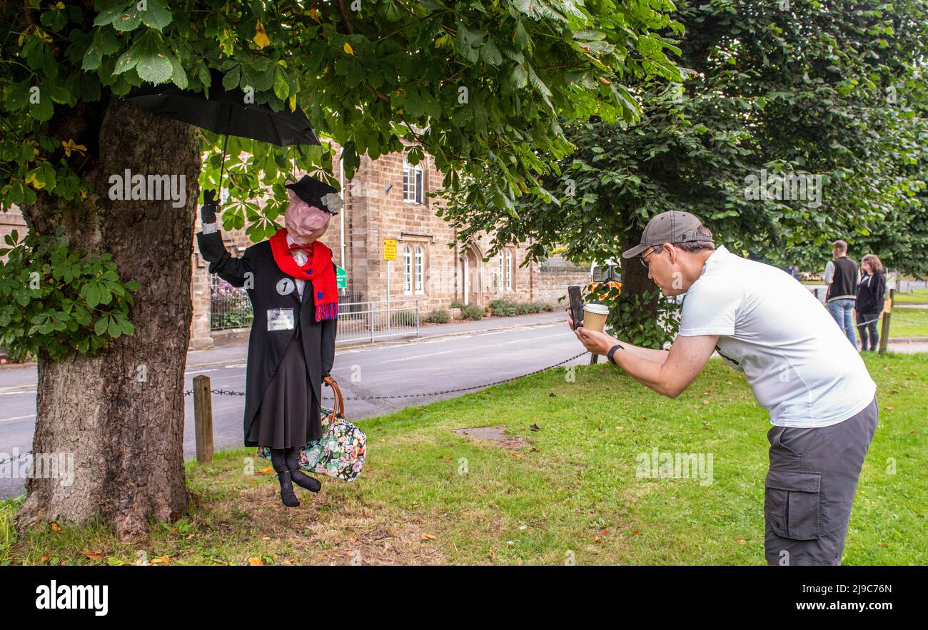A visitor takes a photo of a Mary Poppins scarecrow at the annual ...
