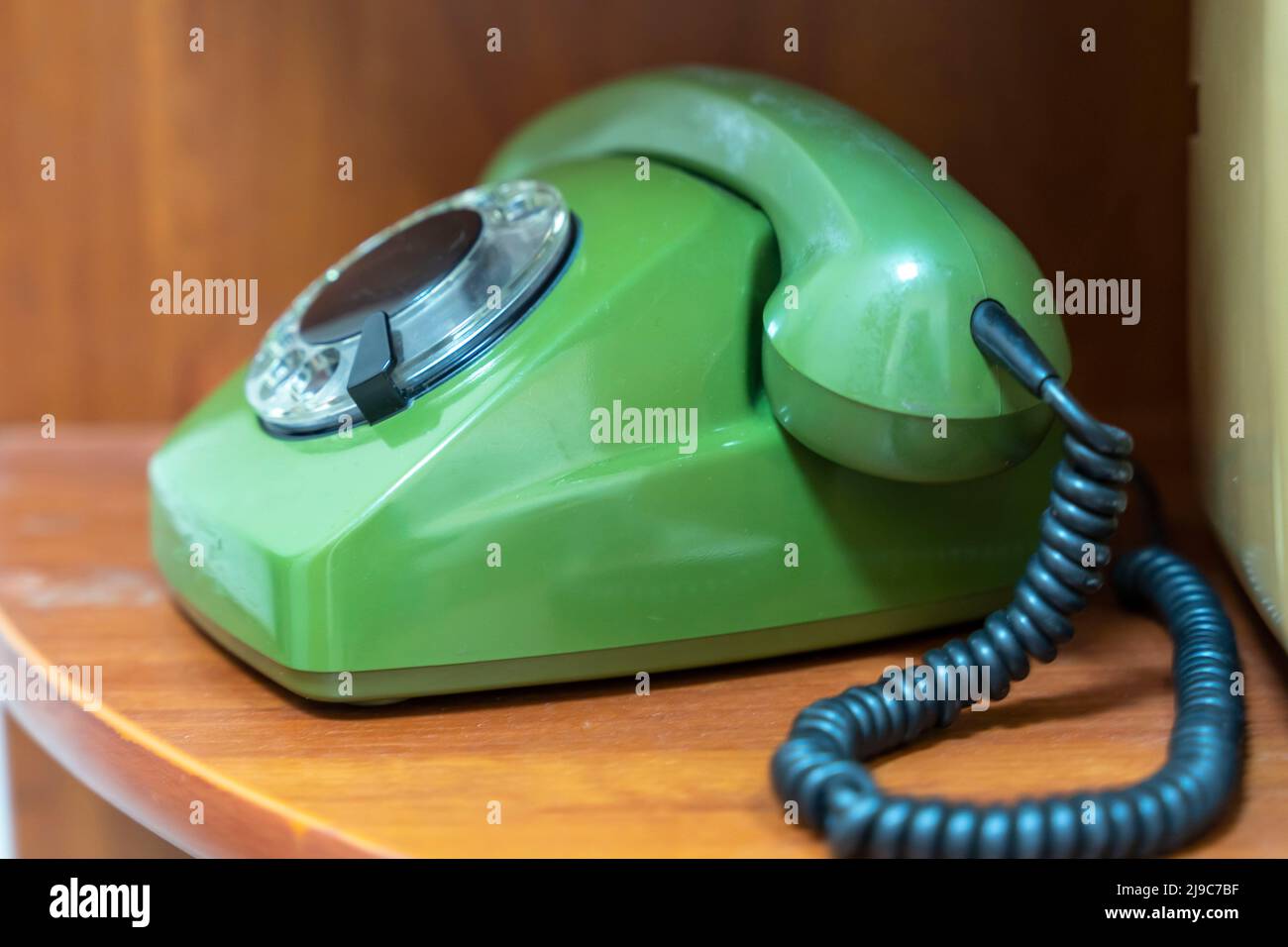 green vintage phone with a rotating dial dial. the phone on the shelf ...