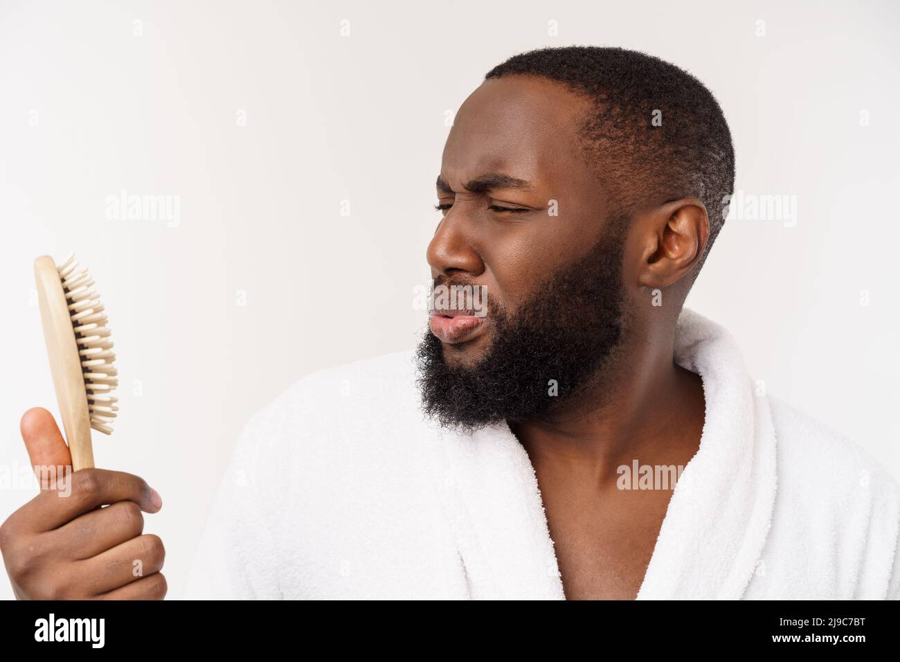 Portrait of handsome young african american man combing his hair in ...