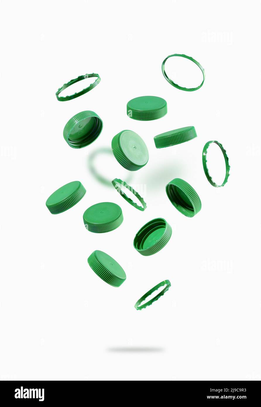 Plastic green bottle caps for recycling on a light gray background ...