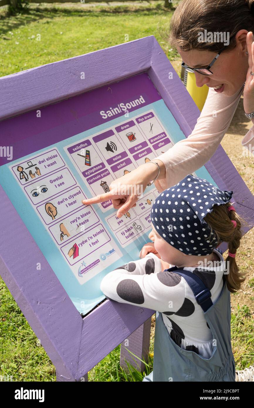 A mother teaching her daughter Welsh words on a Welsh - English ...