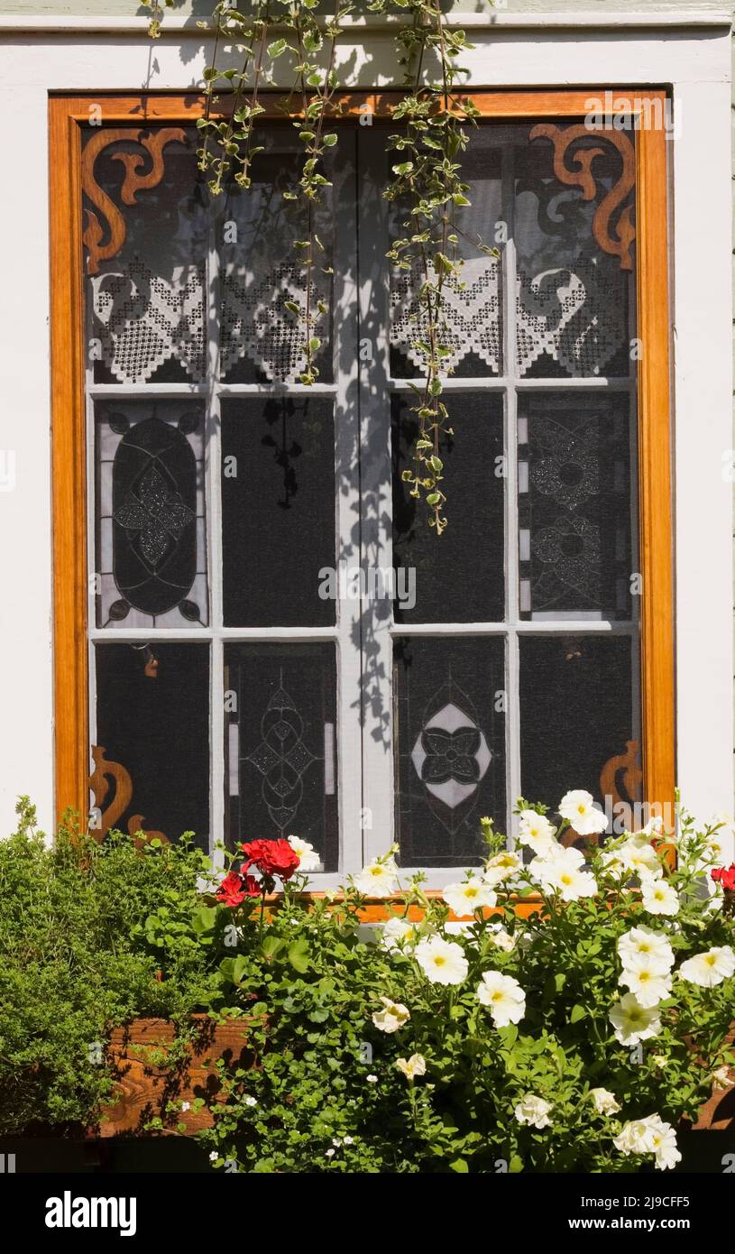 Decorated glass pane window on side of old circa 1900 Canadiana cottage ...