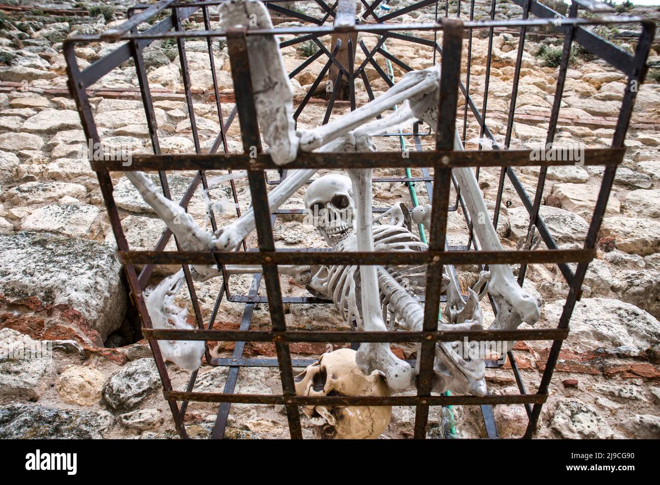 Medieval Metal cage with skeleton for torture, hanging on the castle ...