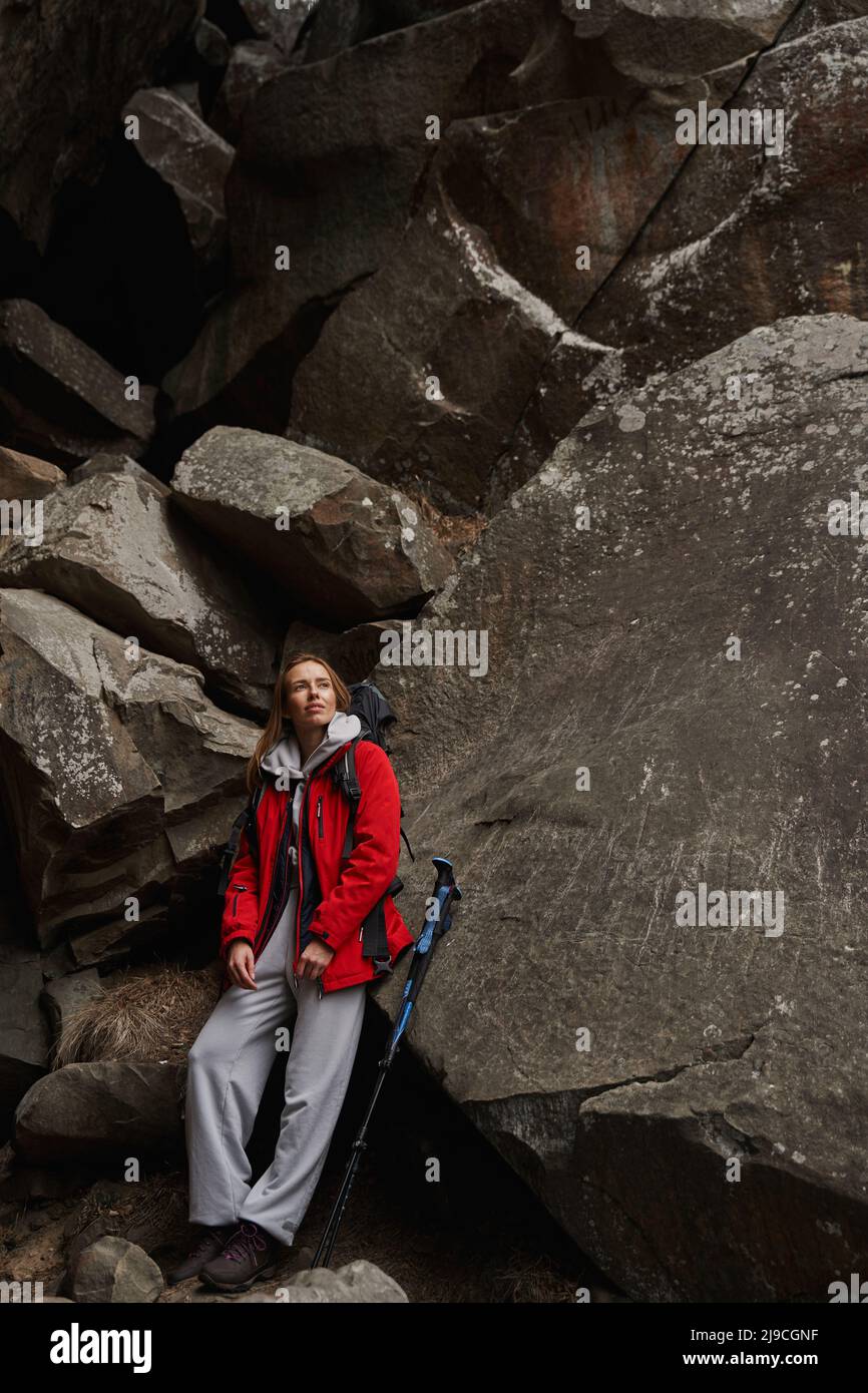 Young female person leaning on the rock Stock Photo - Alamy
