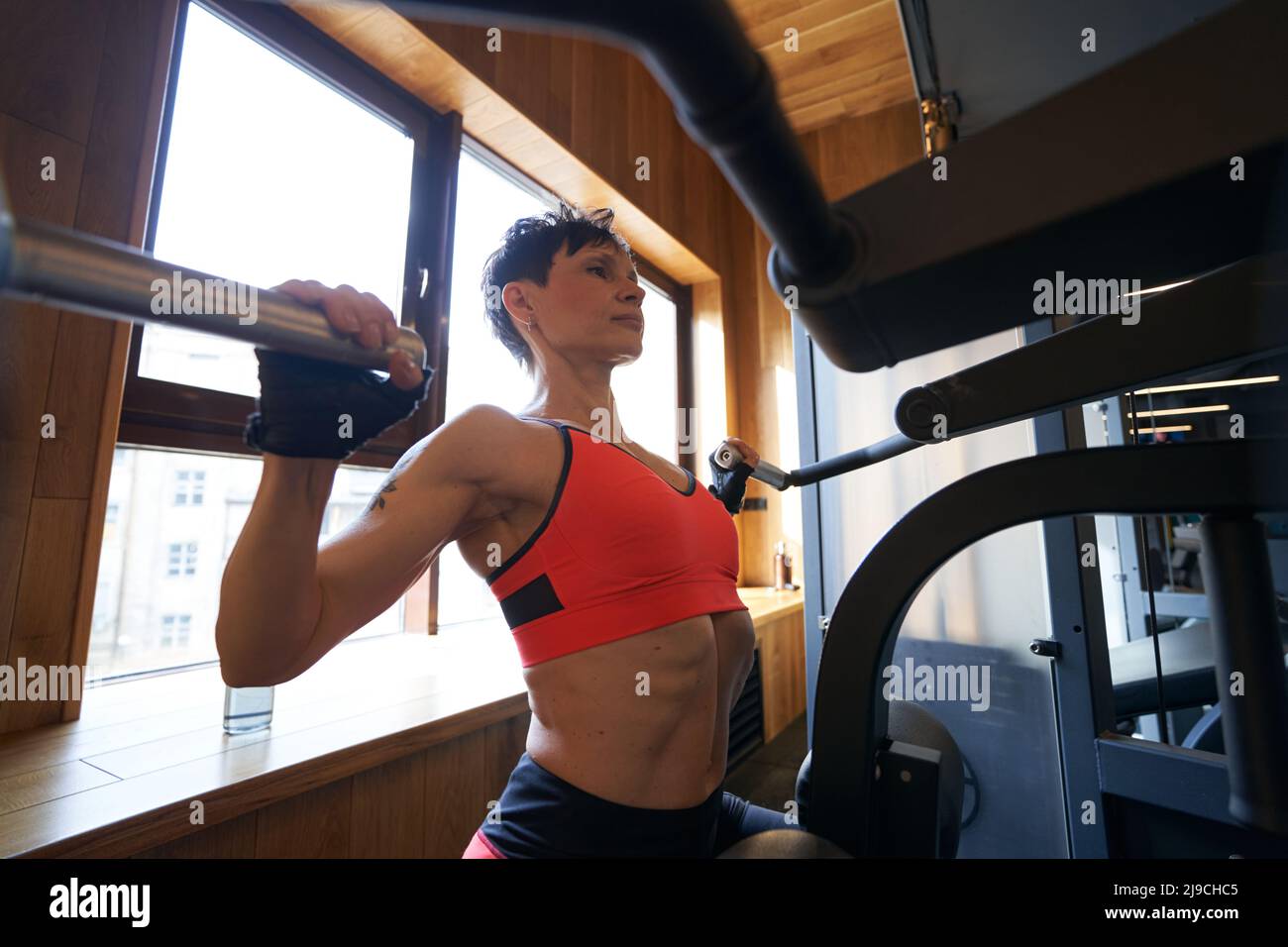 Sportswoman using exercise equipment during gym workout Stock Photo - Alamy