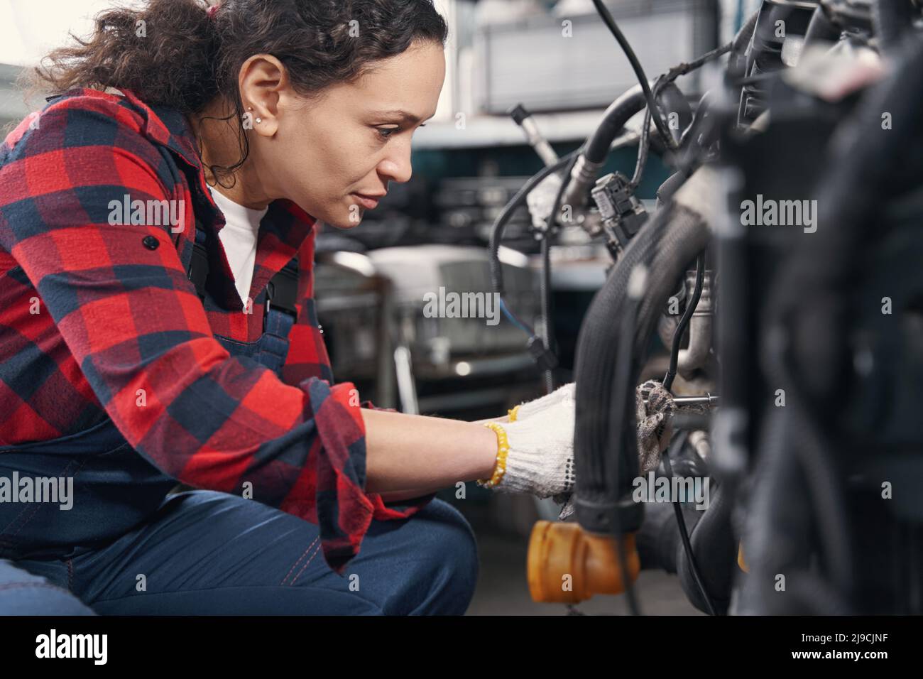 Concentrated female car mechanic fixing auto engine Stock Photo - Alamy