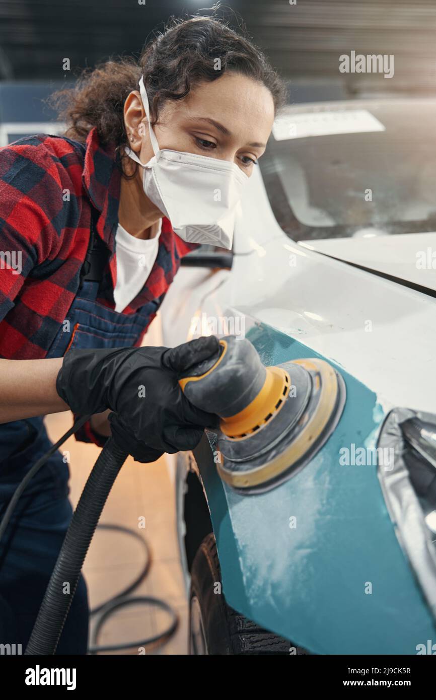 Serious worker grinding car in service center Stock Photo - Alamy
