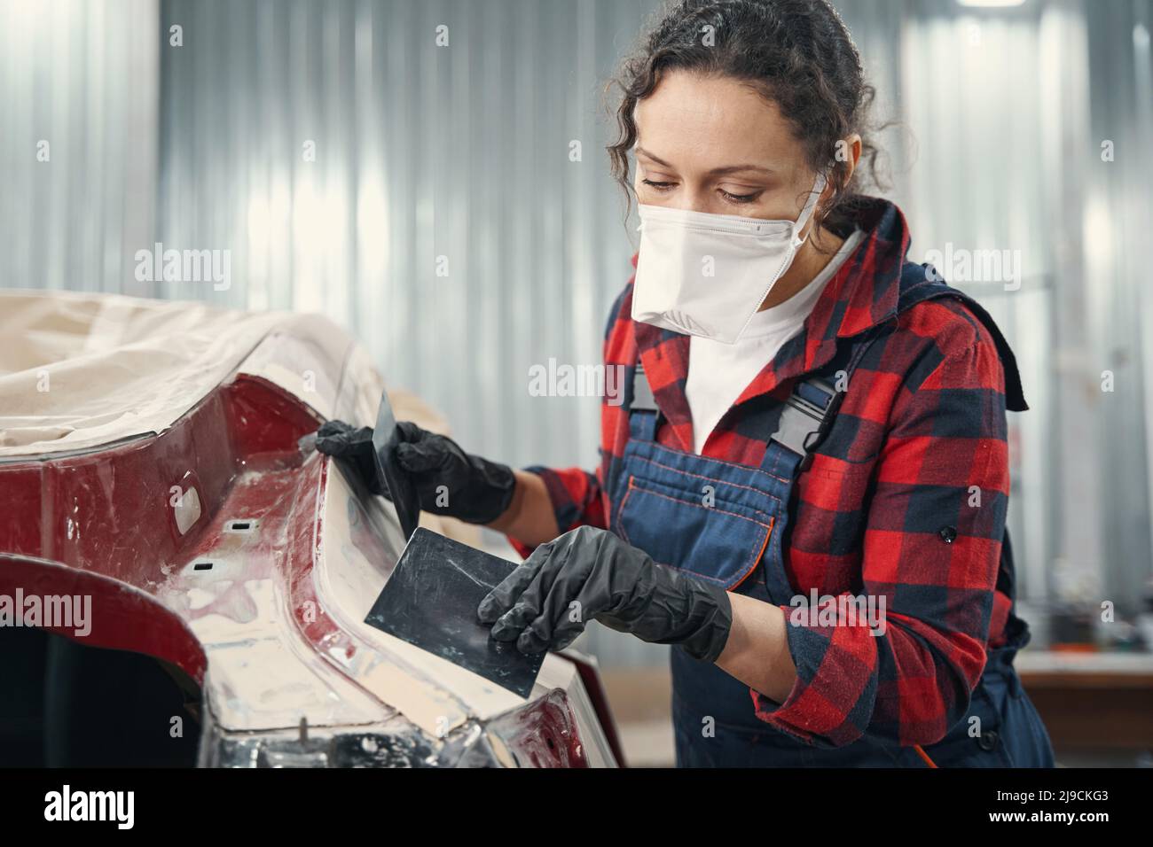 Concentrated female mechanic preparing car for repaint Stock Photo - Alamy