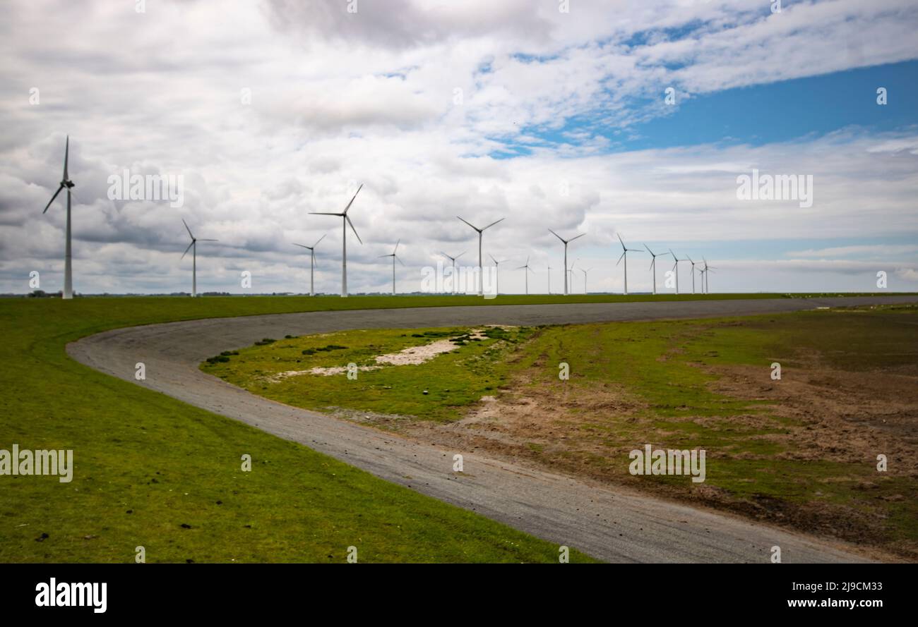 Wind mills on a sunny afternoon on a dyke in Eemshaven, the Netherlands ...