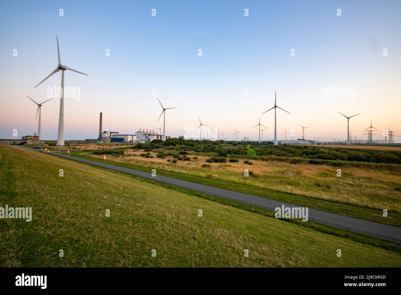 Wind mills on a sunny afternoon on a dyke in Eemshaven, the Netherlands ...
