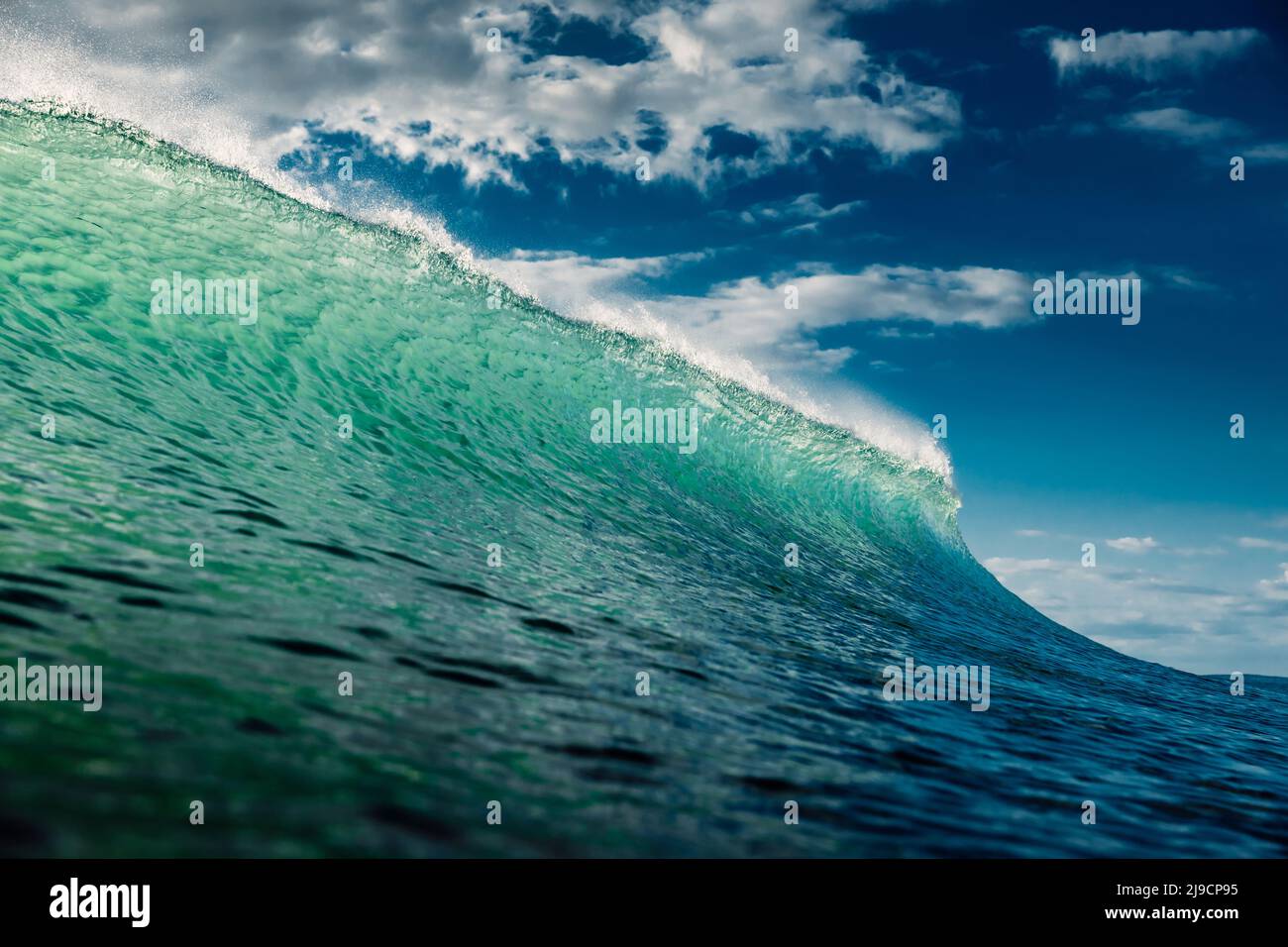 Turquoise wave with sun light breaking in ocean Stock Photo - Alamy