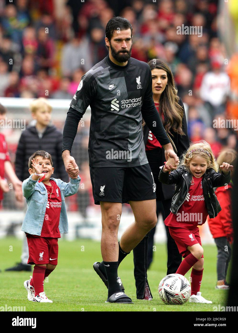 Liverpool goalkeeper Alisson walks the pitch with his family after the ...