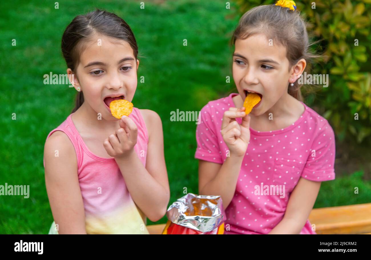 Children eat chips in a friend's park. Selective focus Stock Photo - Alamy
