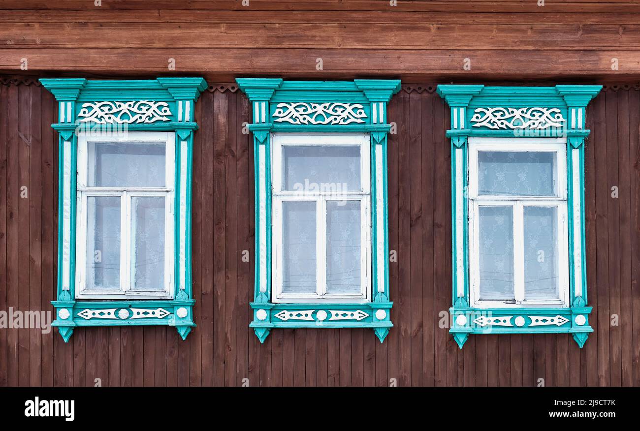 Three old windows with wooden turquoise architraves with patterns on ...
