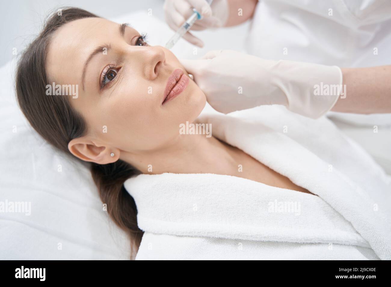 Doctor beautician making contour plastic injection into woman face ...