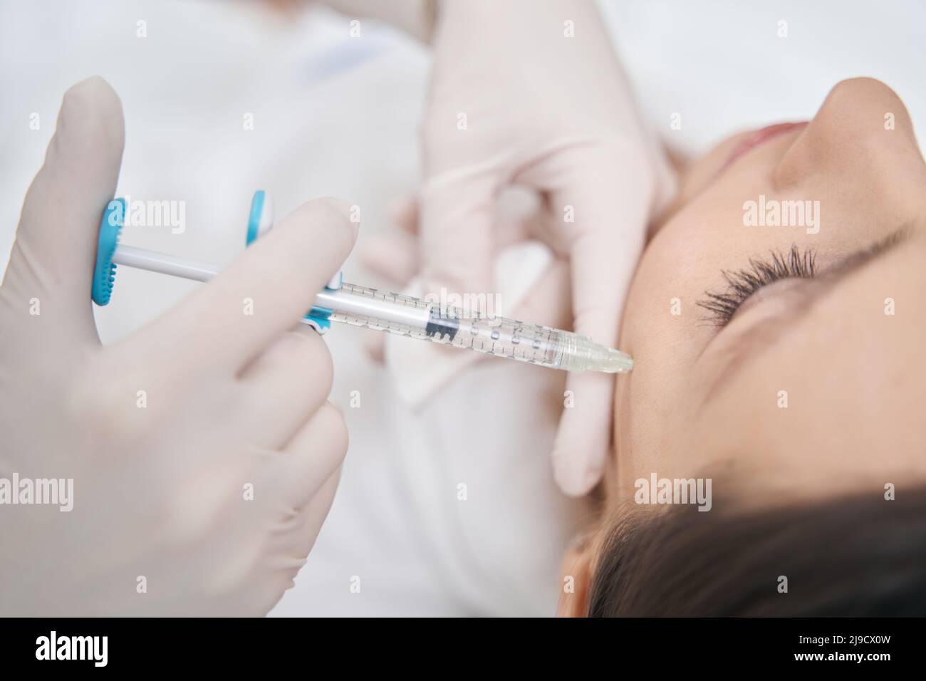 Cosmetologist making rejuvenating facial injection in woman cheek Stock ...