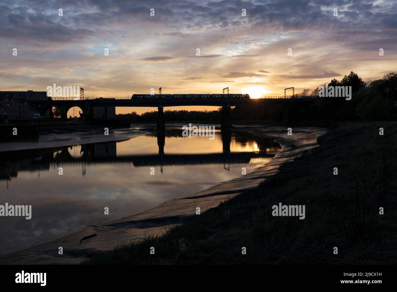Silhouette of a CAF Northern rail class 195 diesel train crossing ...