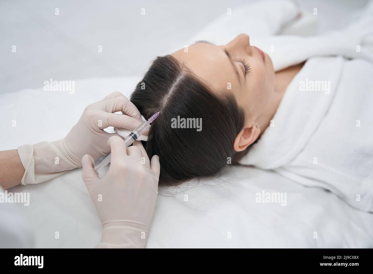 Doctor hands doing injection into woman scalp in beauty salon Stock ...