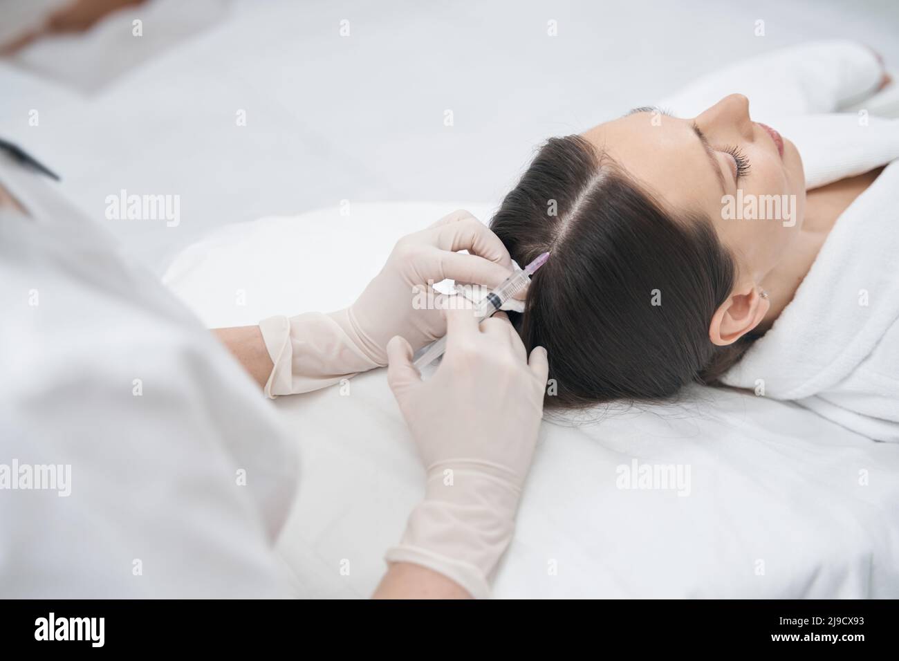 Woman receiving injection into scalp in beauty center Stock Photo - Alamy