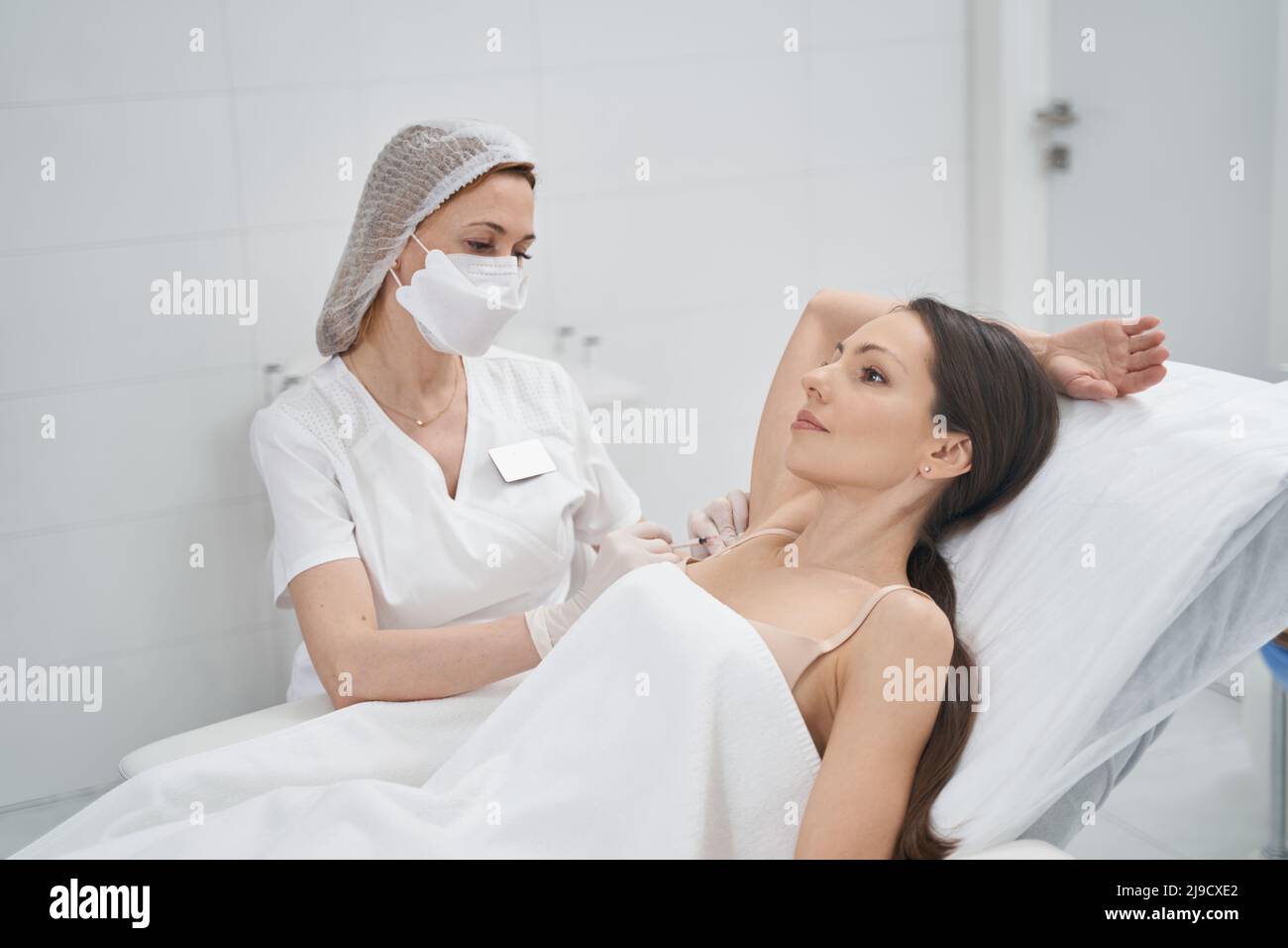 Woman receiving underarm injection hi-res stock photography and images ...