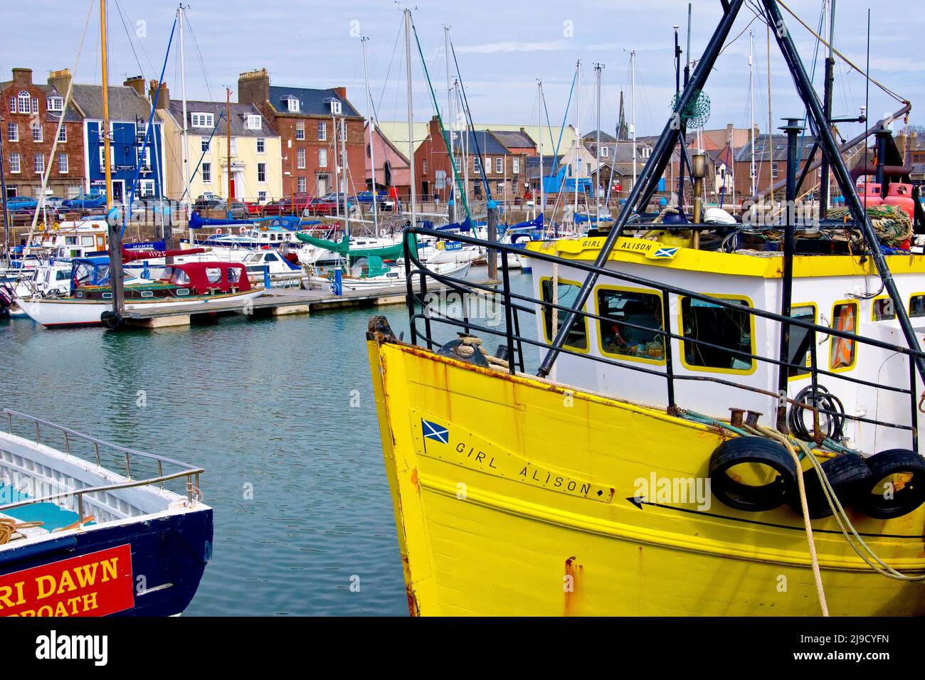 A colourful scene at Arbroath harbour, with several small boats and ...