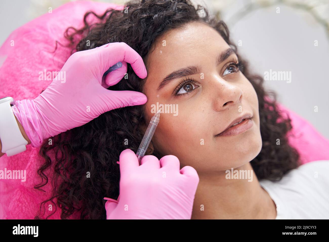 Lady is undergoing professional procedure for strengthening facial skin ...