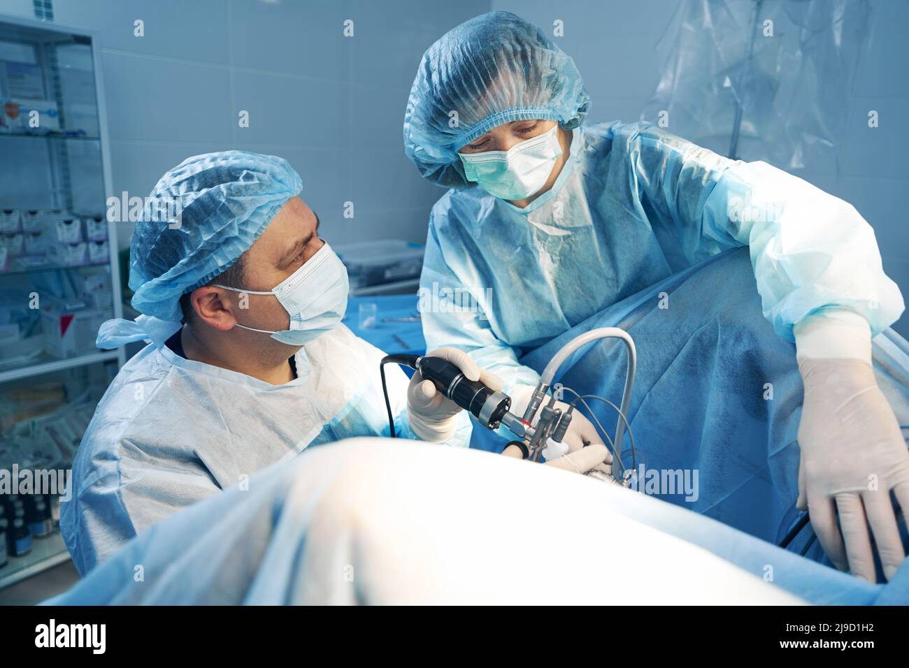 Male and female laparoscopic surgeons using tube camera during ...