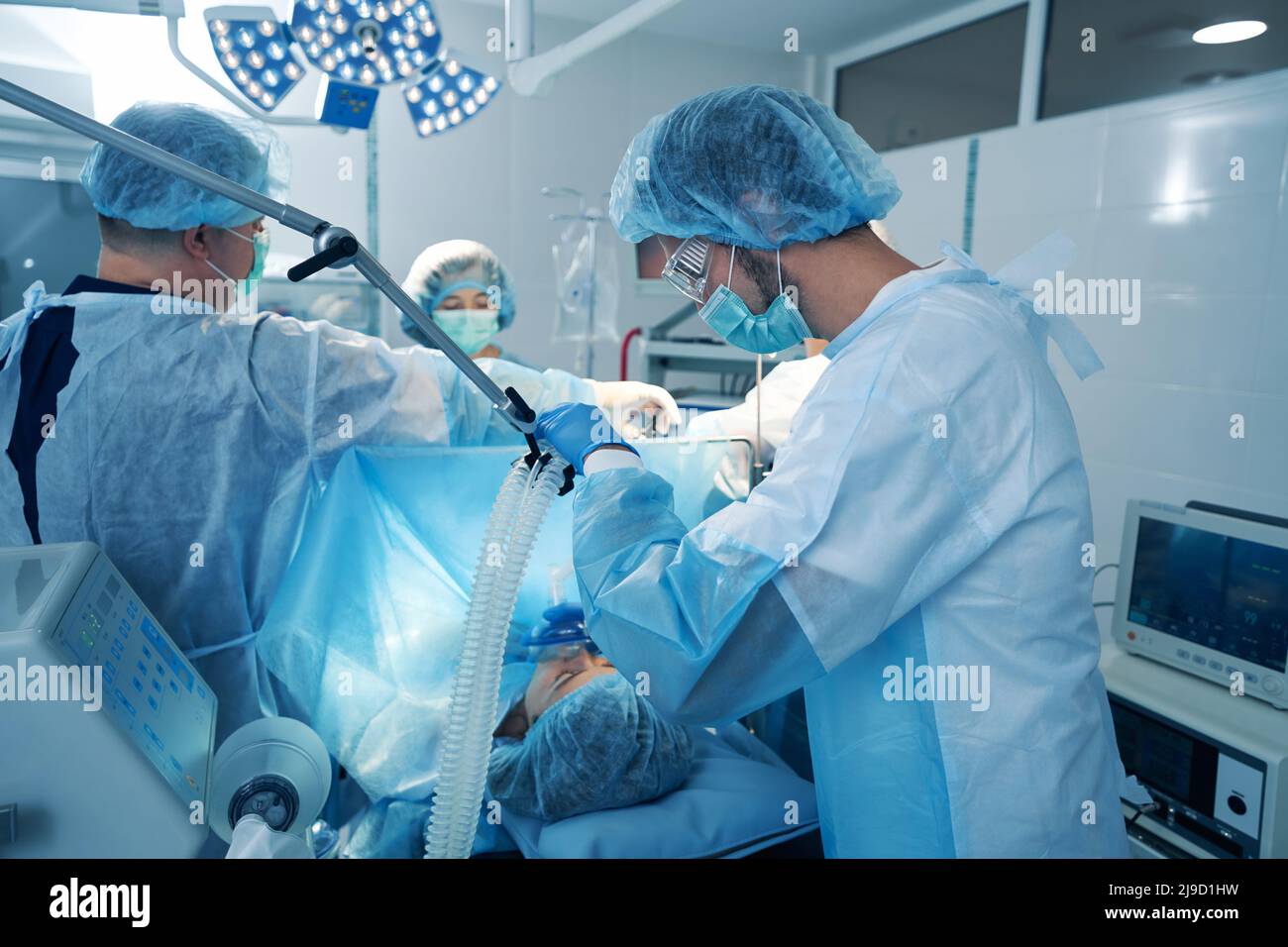 Male anesthesiologist providing anaesthetic gas supply through mask ...