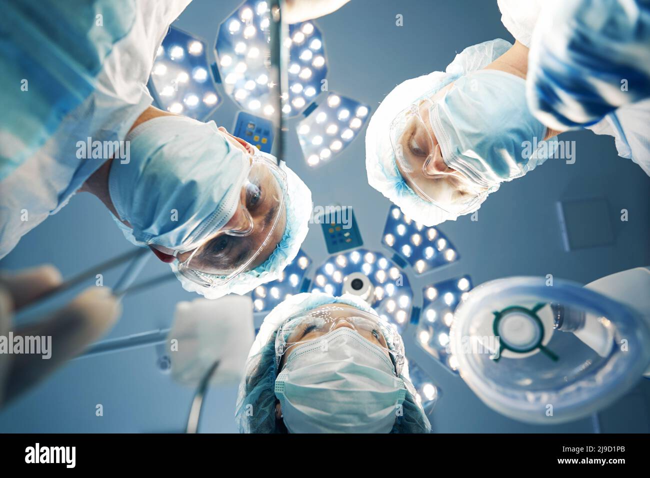 Low angle shot of surgeons with tools over patient Stock Photo - Alamy