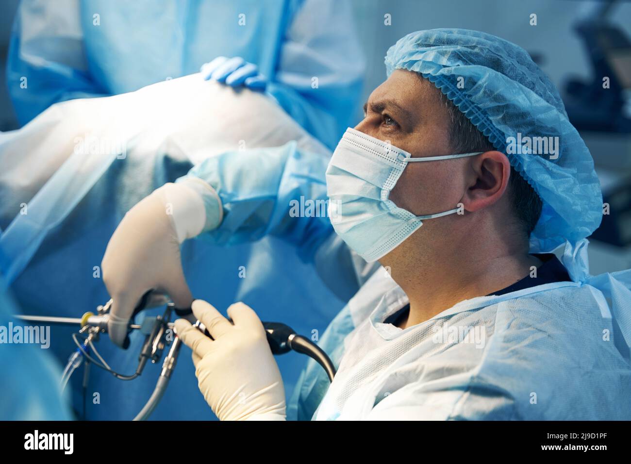 Face of surgeon in mask holding laparoscopic tool Stock Photo - Alamy