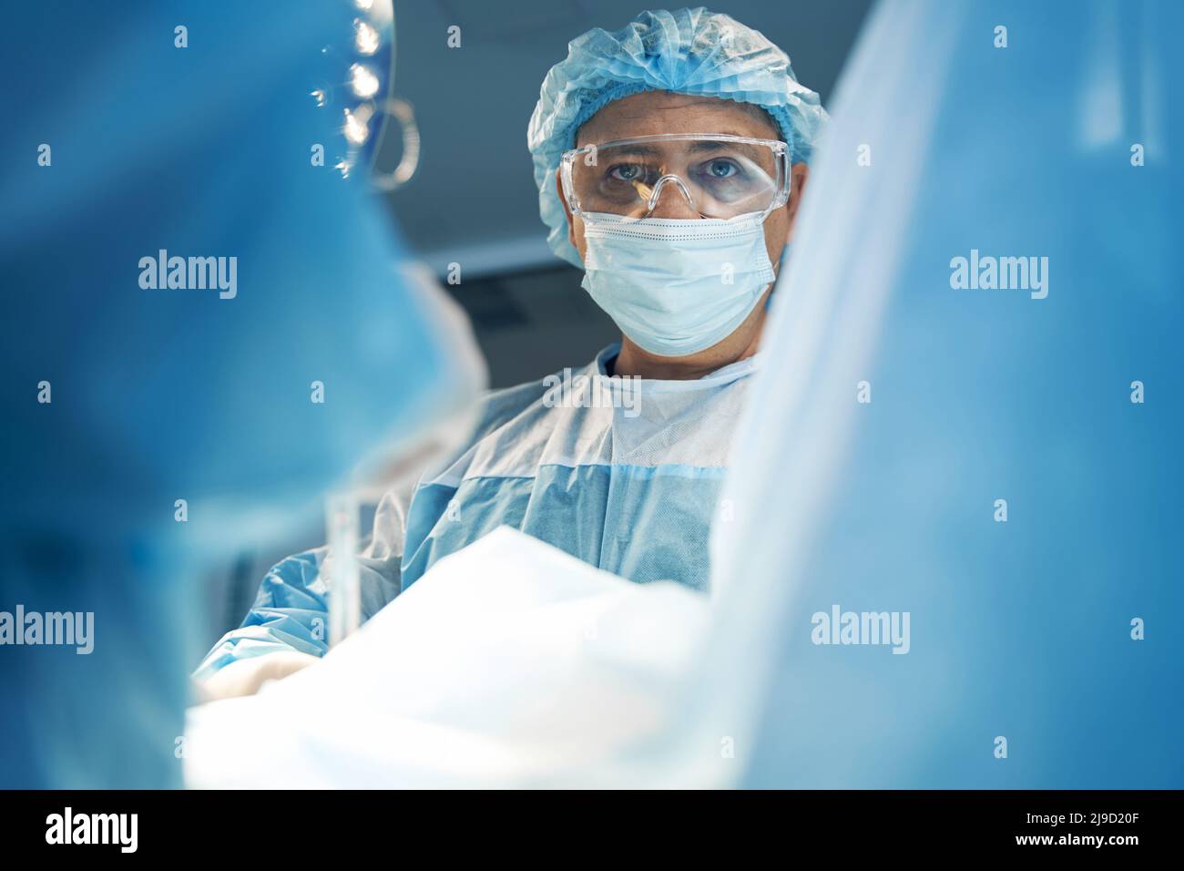 Serious surgeon looking at camera during operation Stock Photo - Alamy