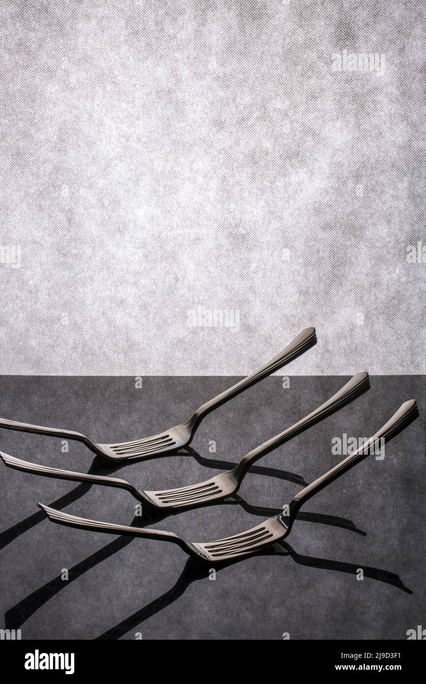 Very simple still life with forks on gray background Stock Photo - Alamy