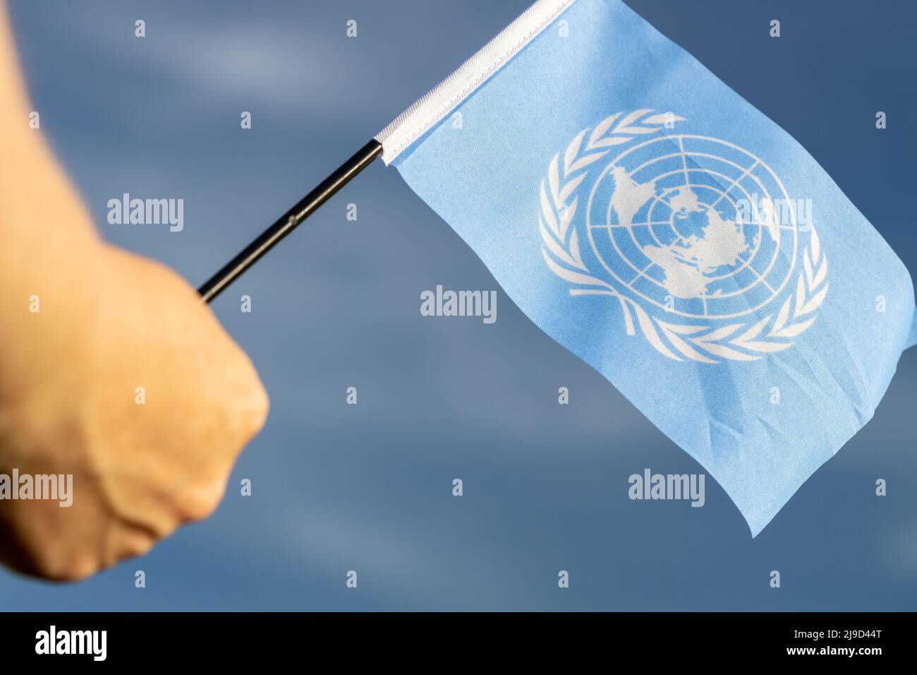 UN flag in a woman's hand against the sky United nations organization ...