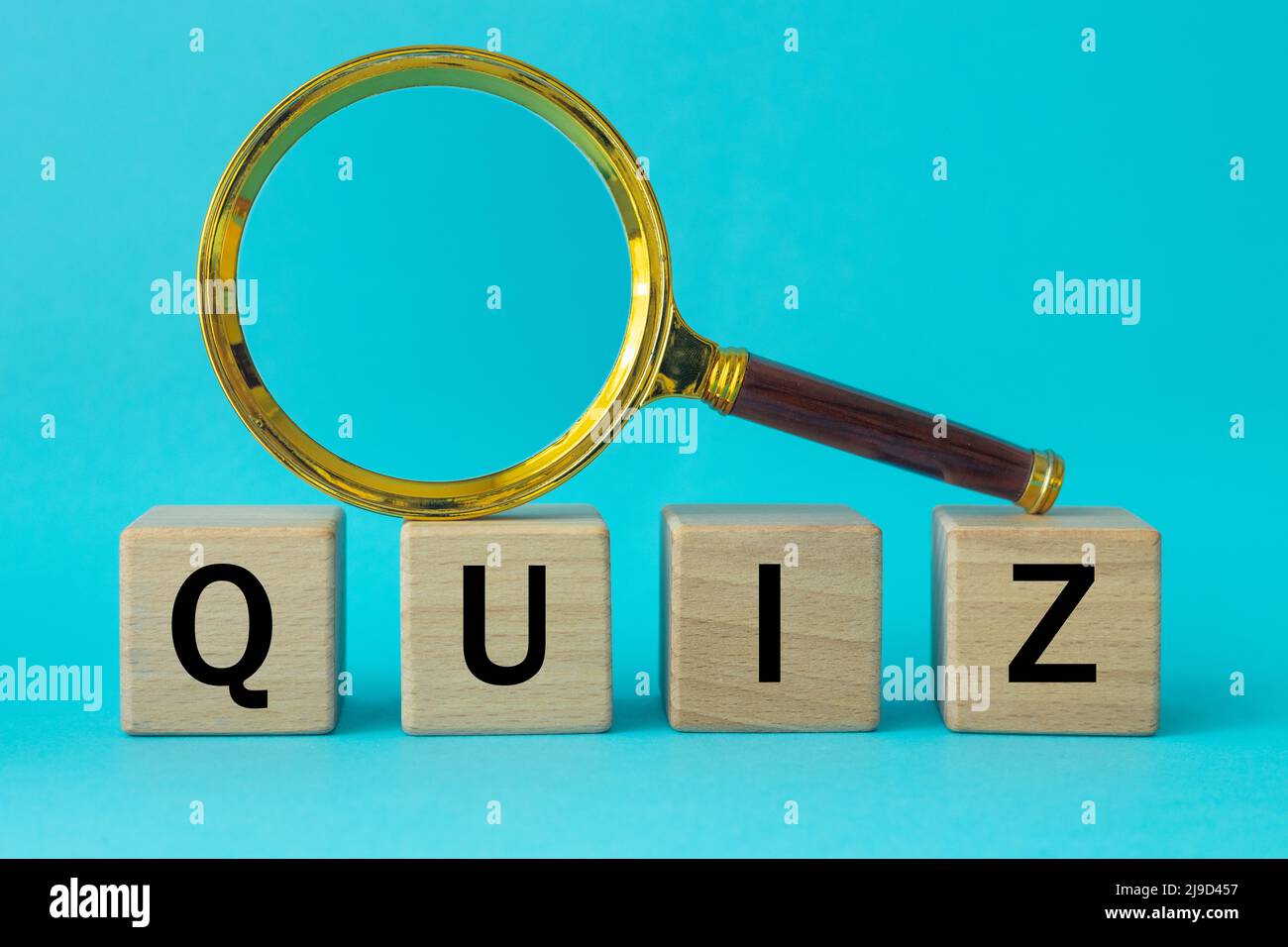 Word Quiz written on wooden blocks and a magnifying glass on a blue ...