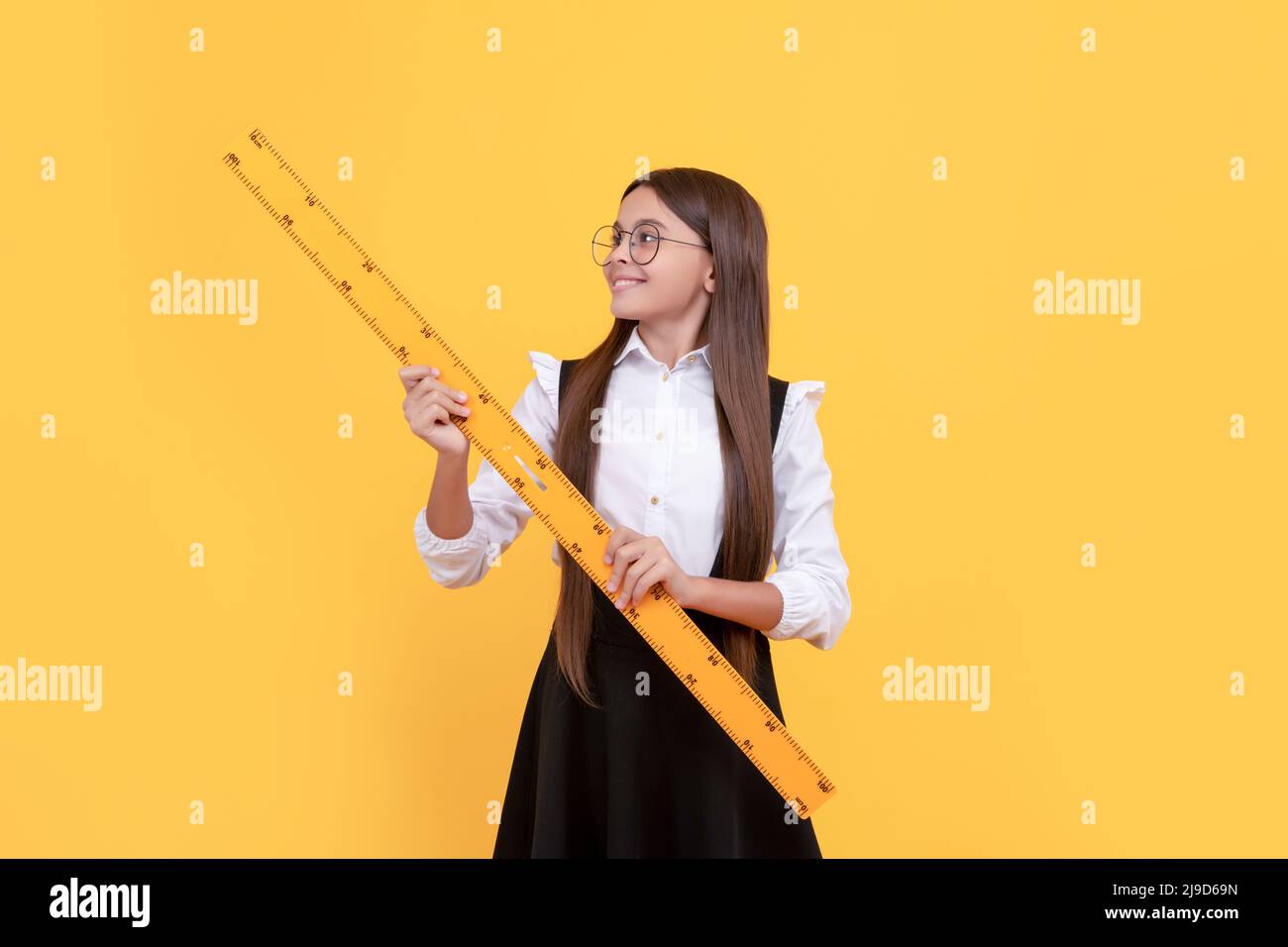 smiling child in school uniform and glasses hold mathematics ruler for ...