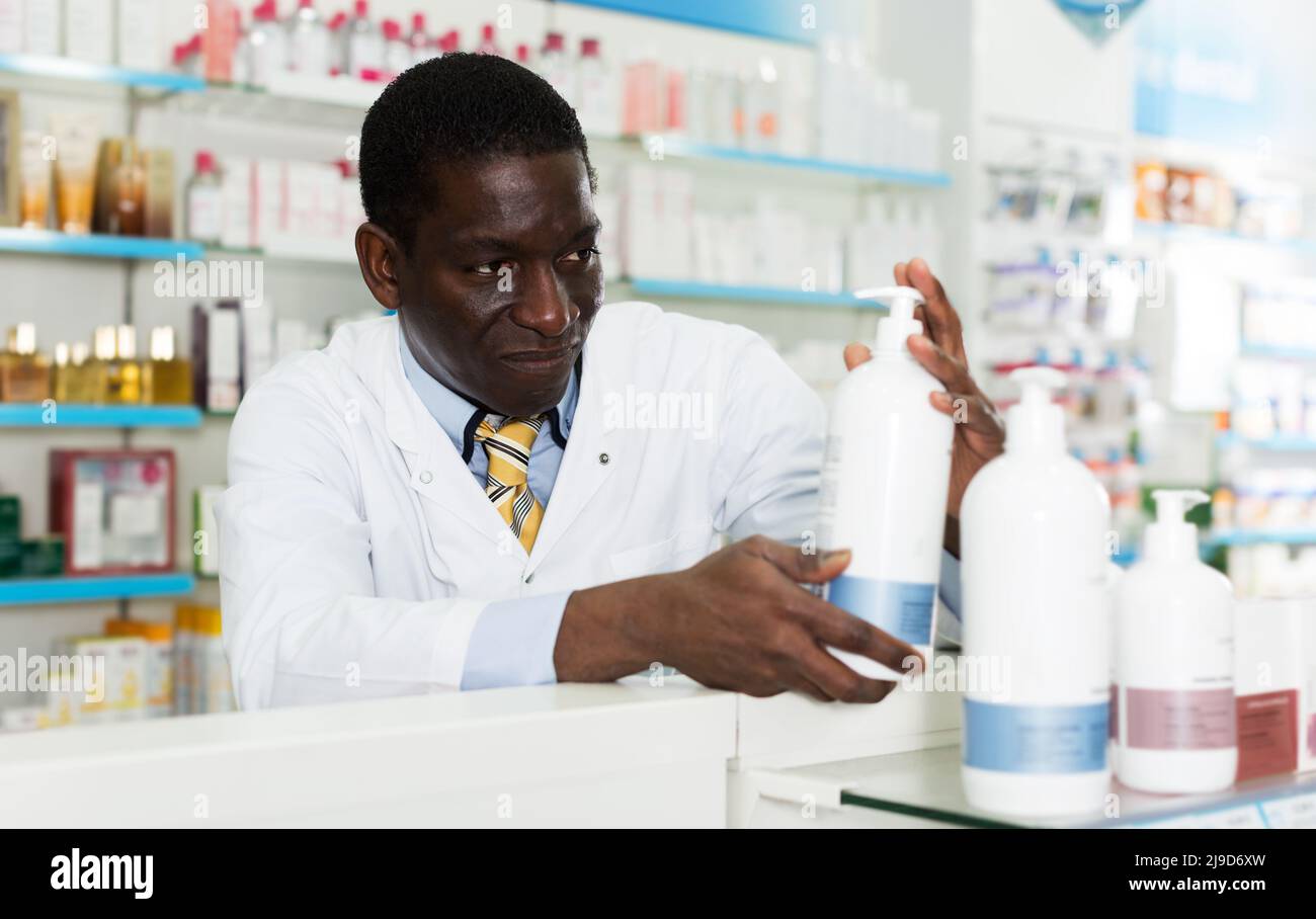 Experienced African American man pharmacist working in modern pharmacy ...