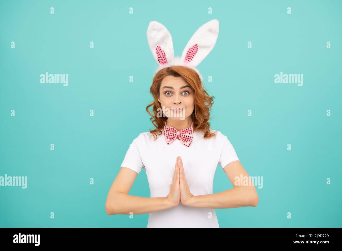 happy easter woman with rabbit ears on blue background. praying Stock ...
