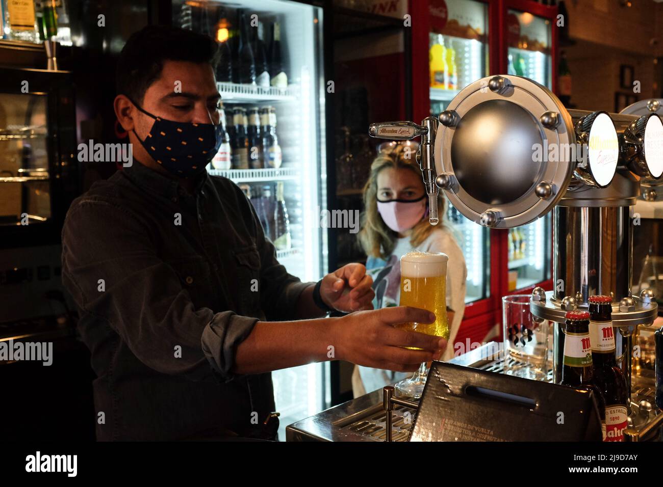 The manager of a bar restaurant in the city centre. pouring a beer ...