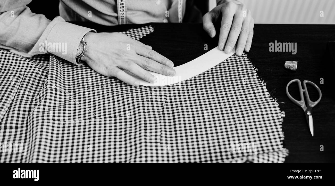 tailor working with sewing pattern in atelier. individual tailoring ...