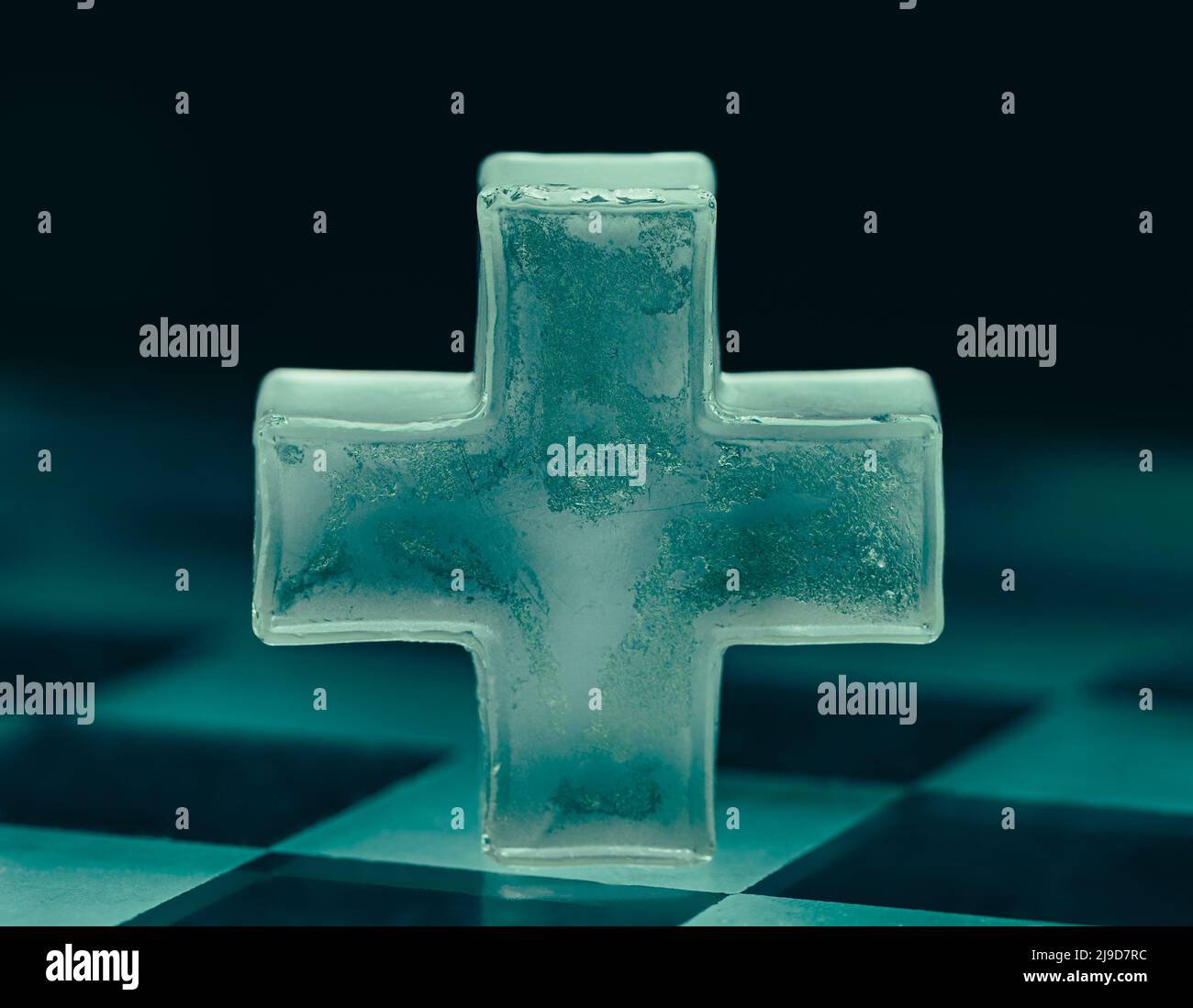Glass cross on a chessboard. Close up Stock Photo - Alamy