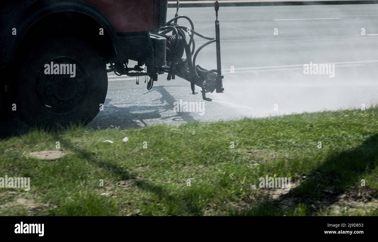 Watering machine washes city road with water. Cleaning sweeper machine ...