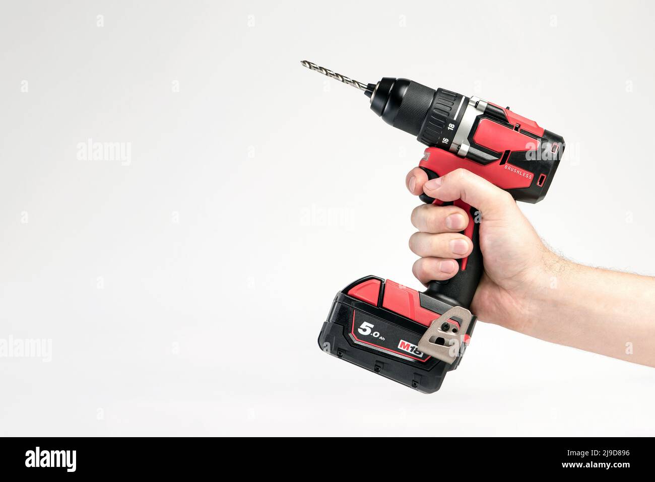 Cordless drill in black and red. Screwdriver with a drill in hand on a ...