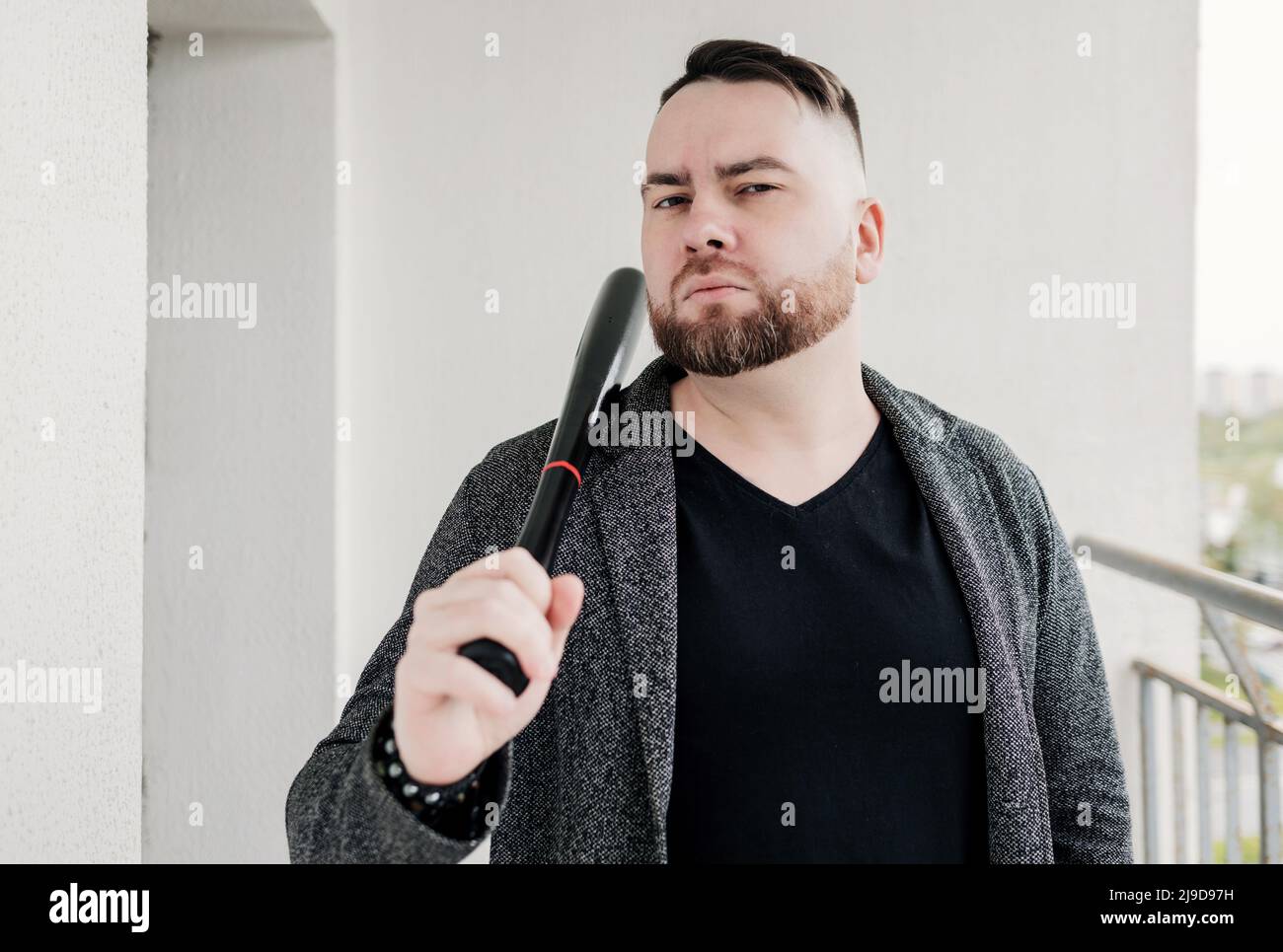 dangerous bearded man with black bat. macho with haircut Stock Photo ...
