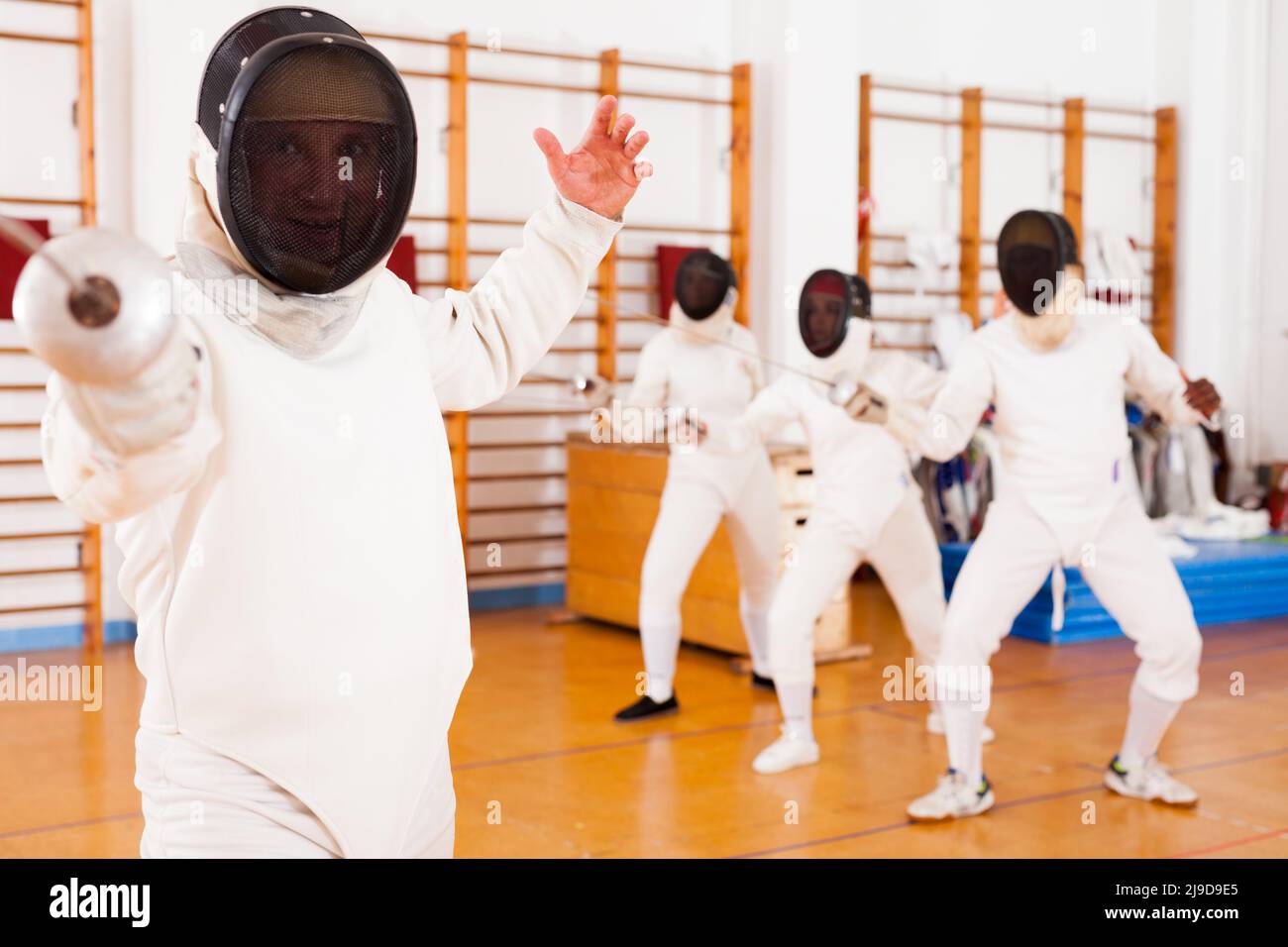 Sporty young man fencer practicing effective fencing techniques in ...
