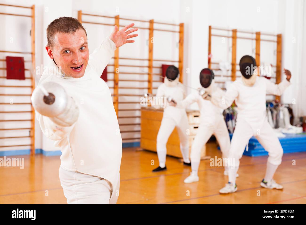Sporty young man fencer practicing effective fencing techniques in ...